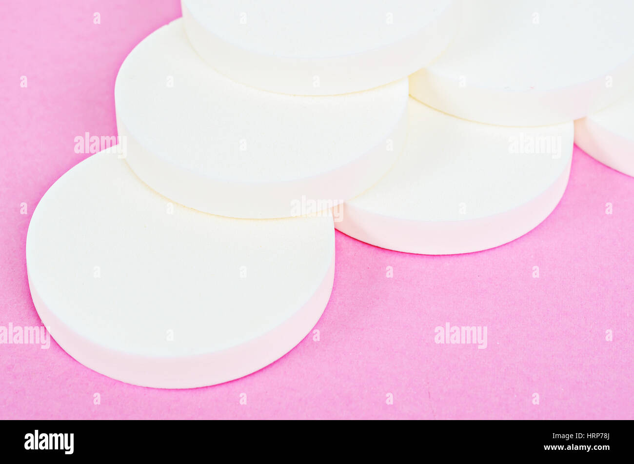 White circle shape cosmetic sponges on pink background Stock Photo - Alamy