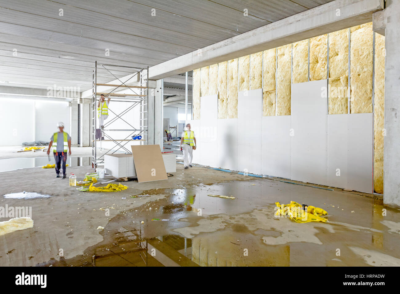 Workers are assembly gypsum wall. Plasterboard is under construction ...