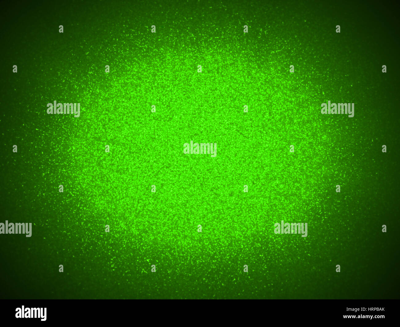 twinkling green glitter lit by a bright spotlight with a dark vignette ...