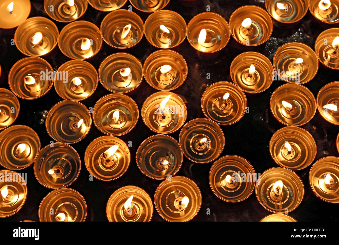 many candles lit with the warm flame during the religious rite Stock ...