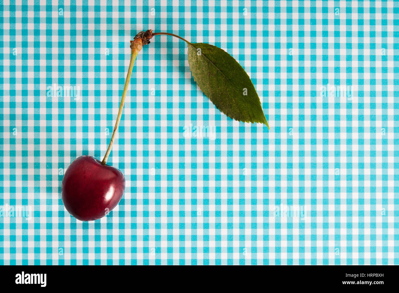one red cherry on a retro background Stock Photo - Alamy