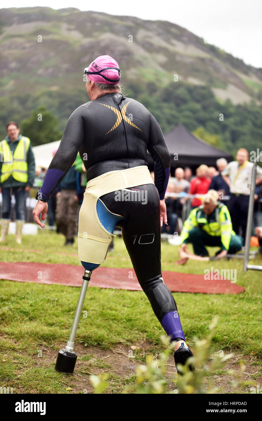 Disabled swimmer with one leg climbs out of Ullswater Lake having swum ...