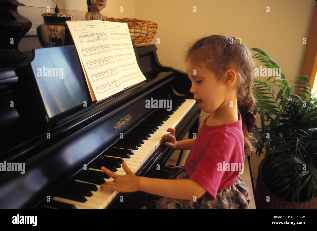 Young child practicing her scales on the piano at home. MR Stock Photo ...