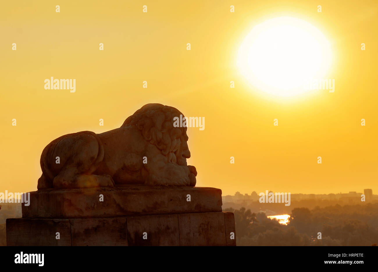 Lion statue with landscape at sunrise Stock Photo - Alamy