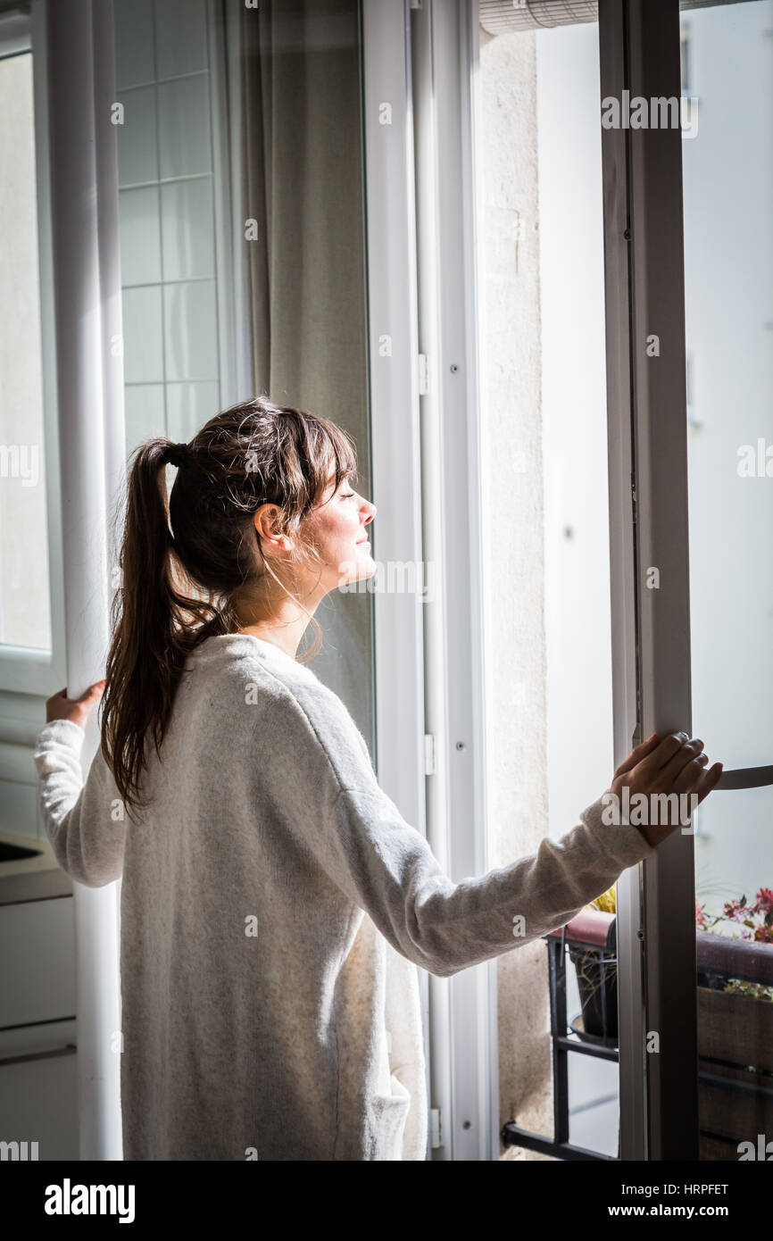 Woman opening window Stock Photo - Alamy
