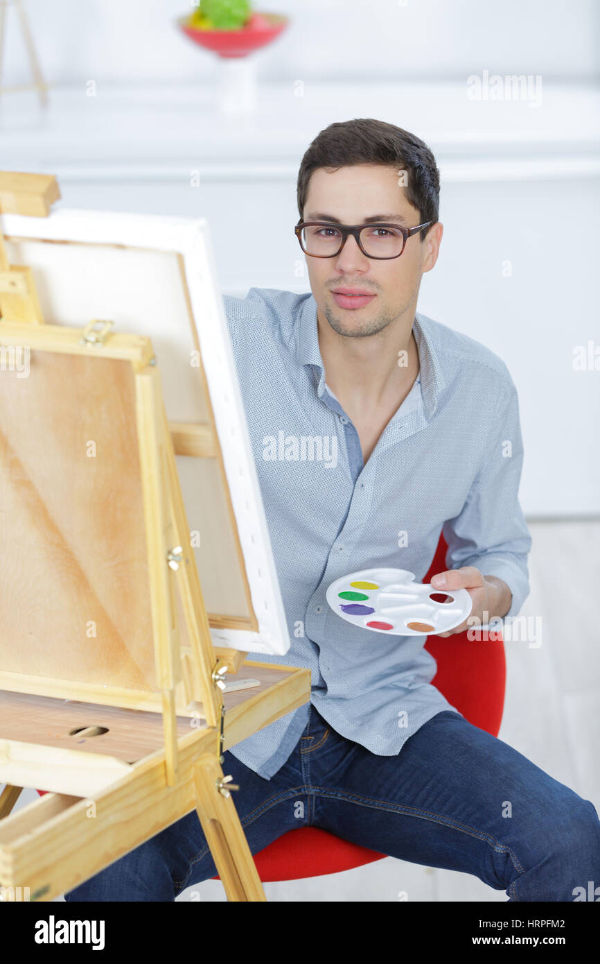 young man artist paints on canvas with oil paints Stock Photo - Alamy
