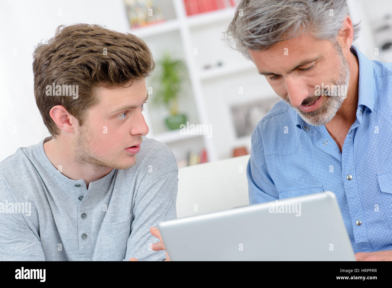 Two men looking at tablet computer Stock Photo - Alamy