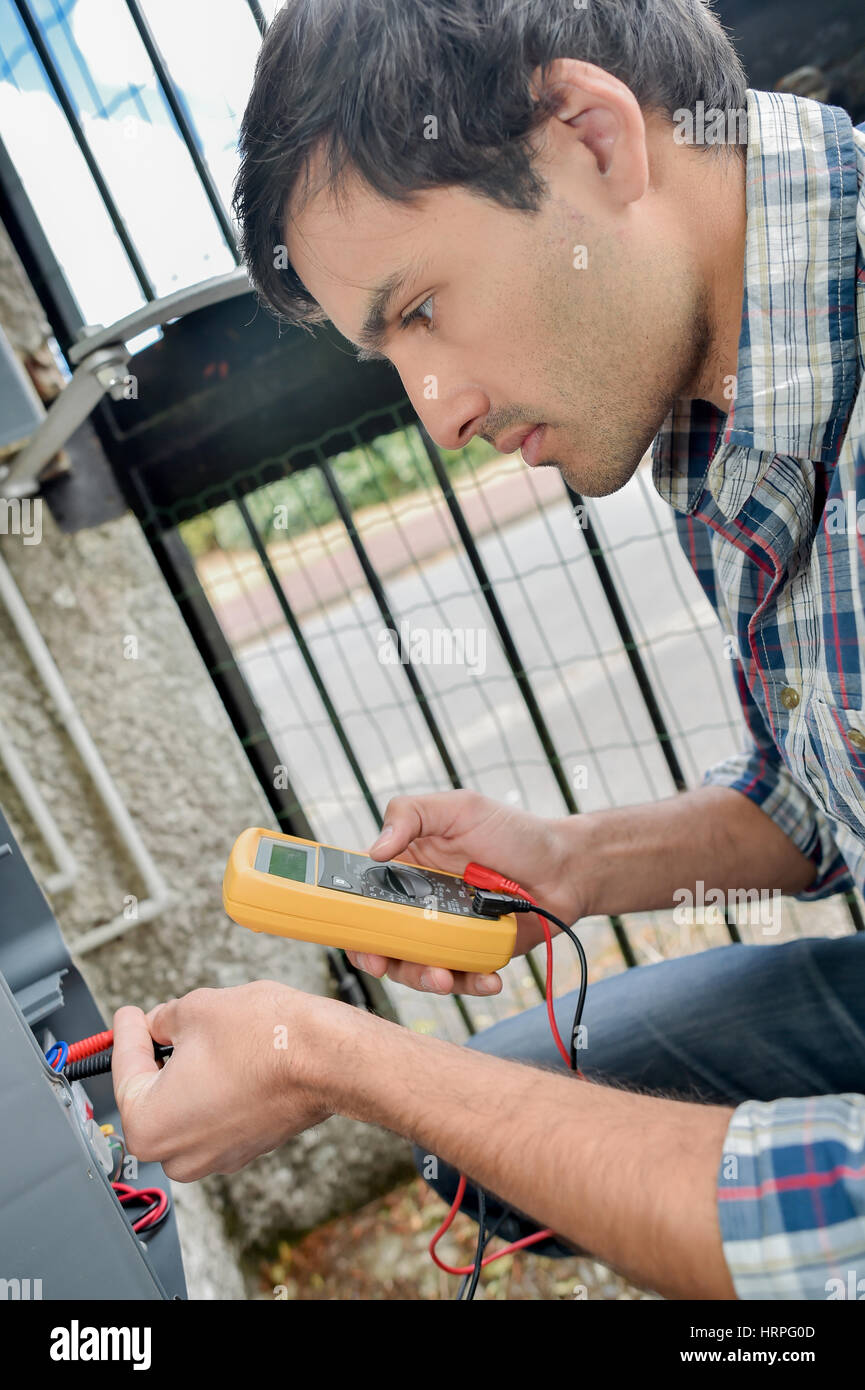 Man using multimeter on exterior electrical box Stock Photo - Alamy