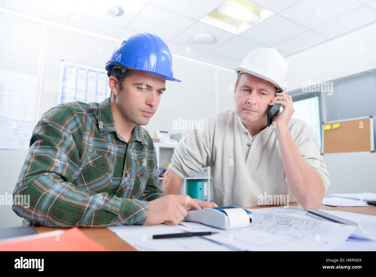 Two architect looking over plans Stock Photo - Alamy