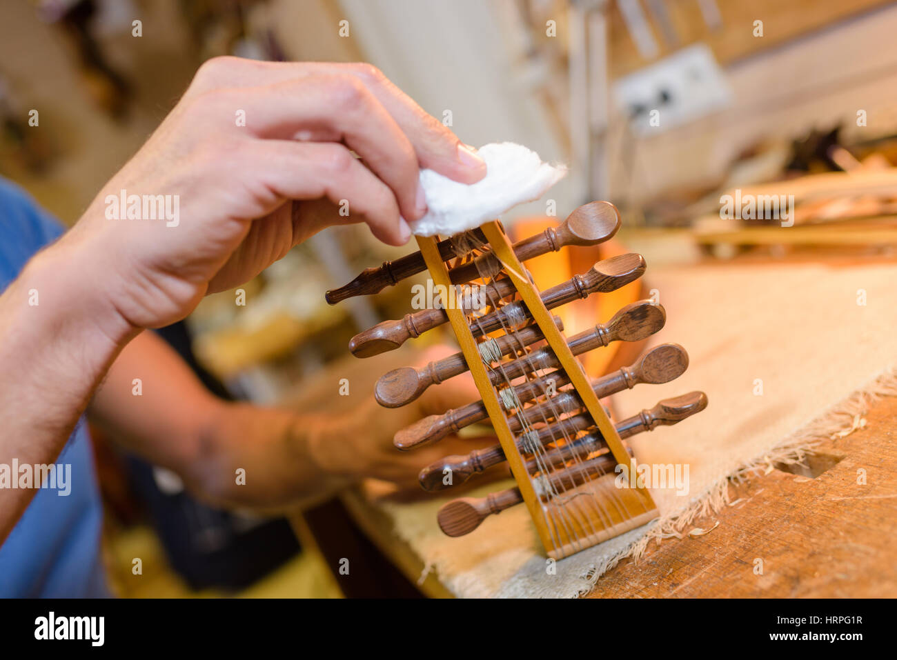 Man polishing pegs of instrument Stock Photo - Alamy