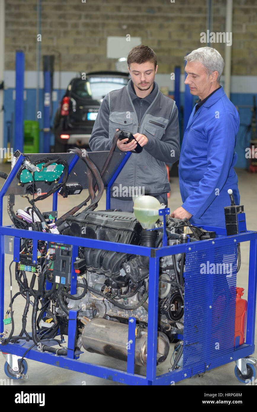 apprentice mechanic working on engine block with senior teacher Stock ...