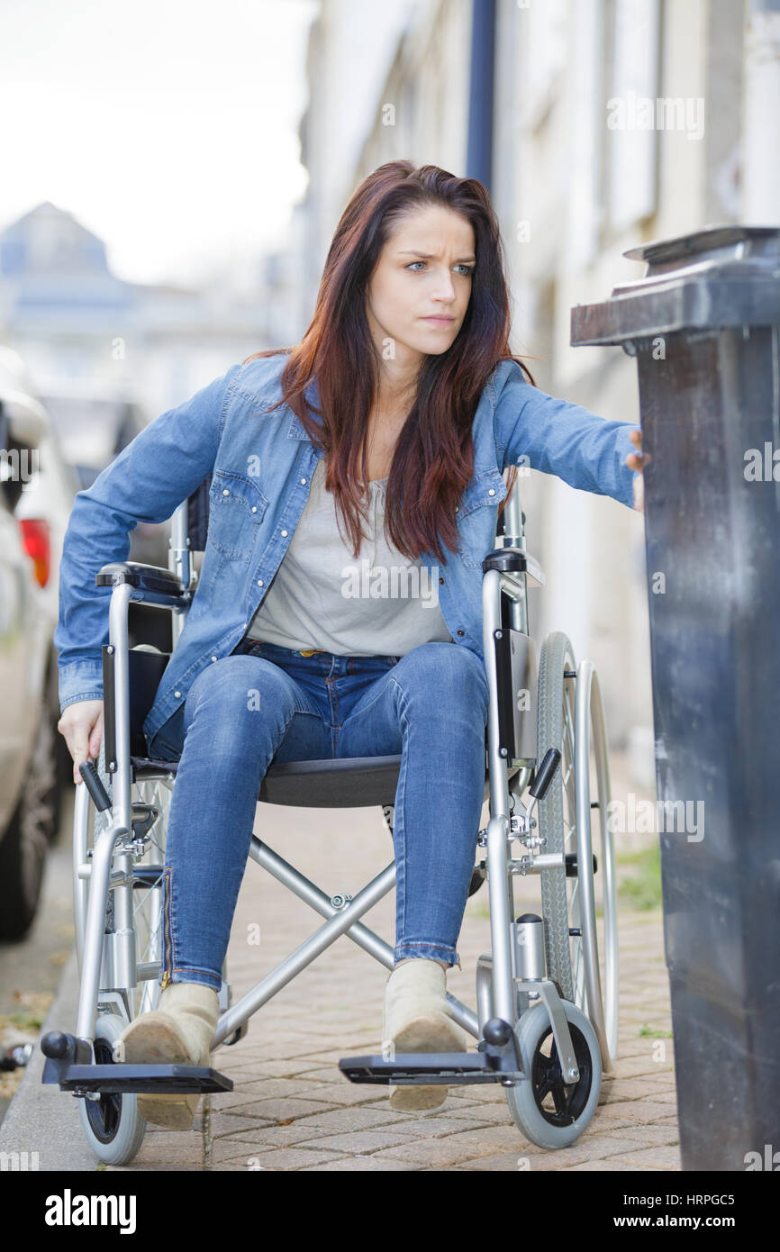 Woman in wheelchair struggling to pass obstruction Stock Photo - Alamy