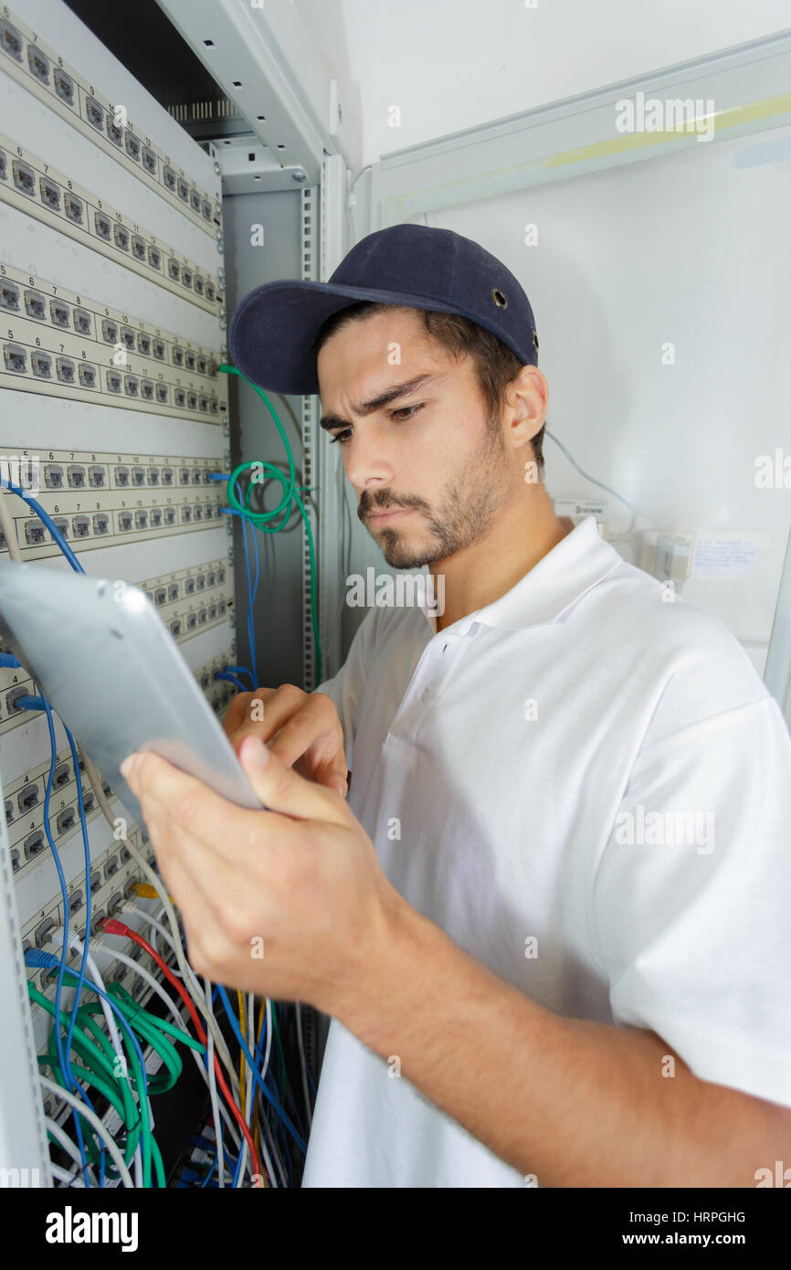 focused electrician applying safety procedure while working on ...