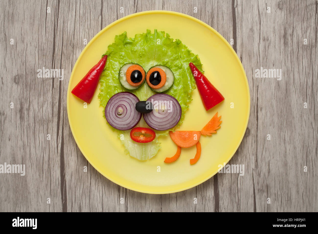 Funny vegetable dog made on plate and table Stock Photo - Alamy