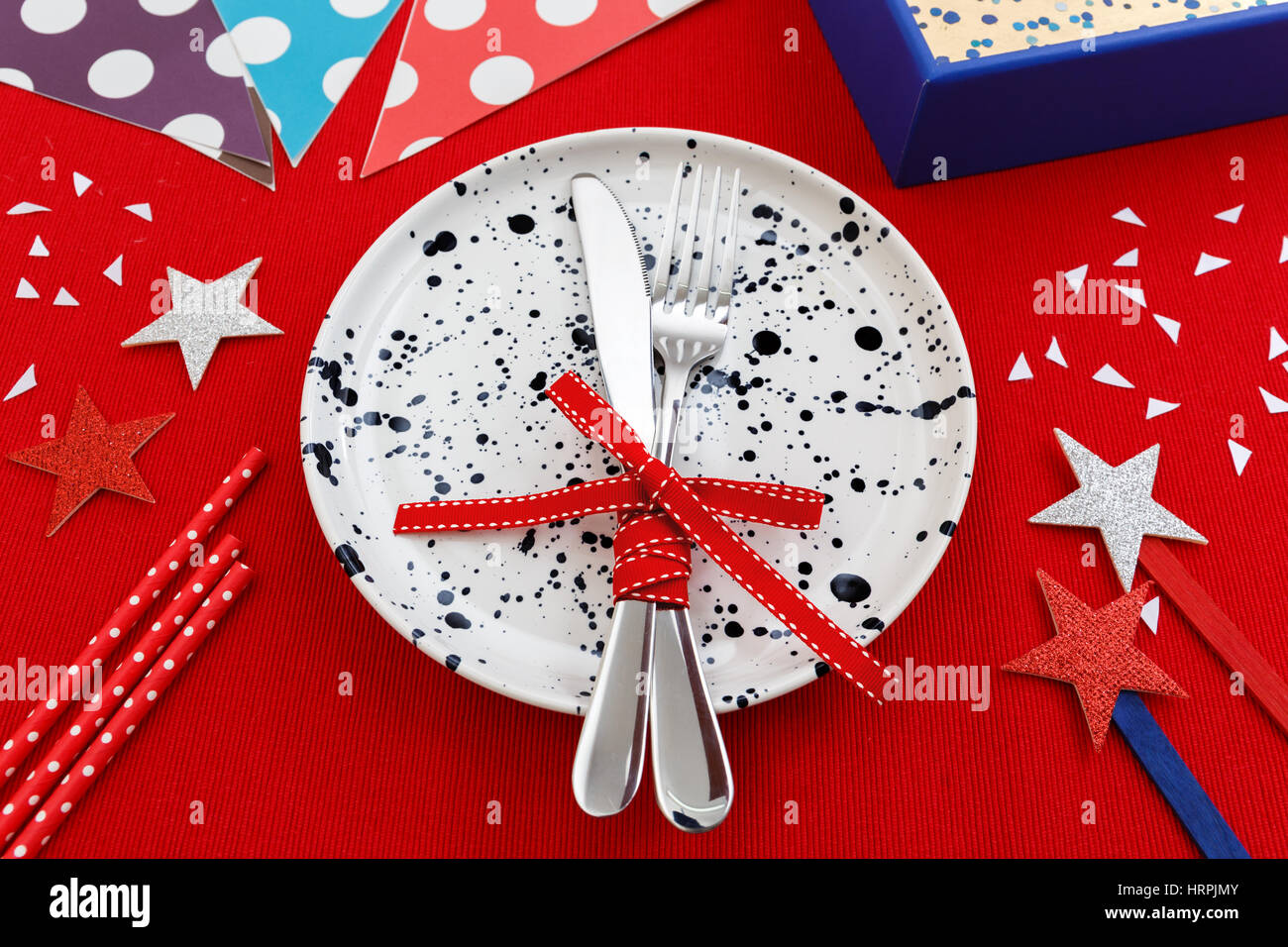 Party and celebration table setting with gift box on red tablecloth ...