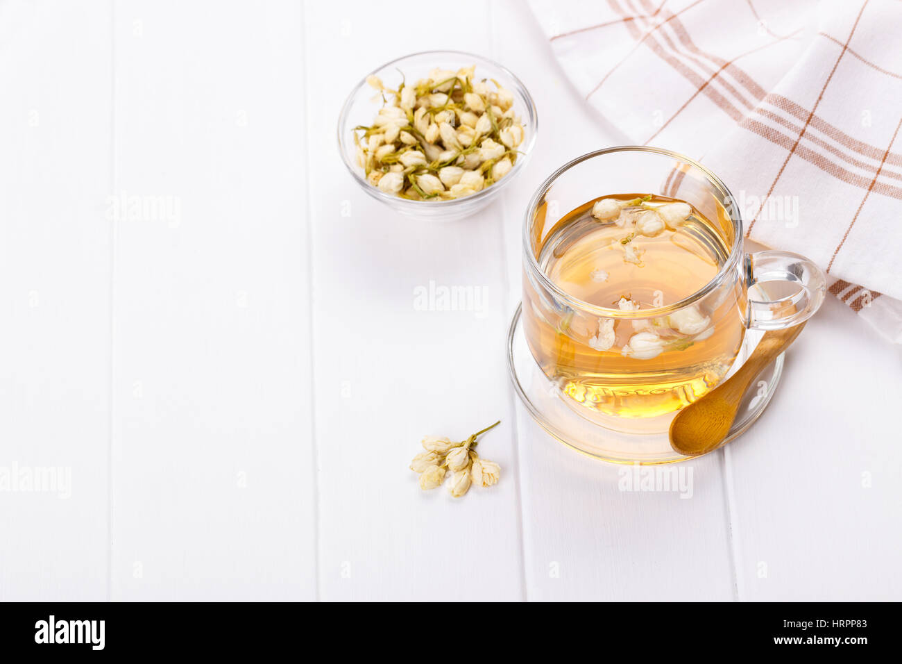 Glass cup of organic asian jasmine tea with flowers on white wooden ...