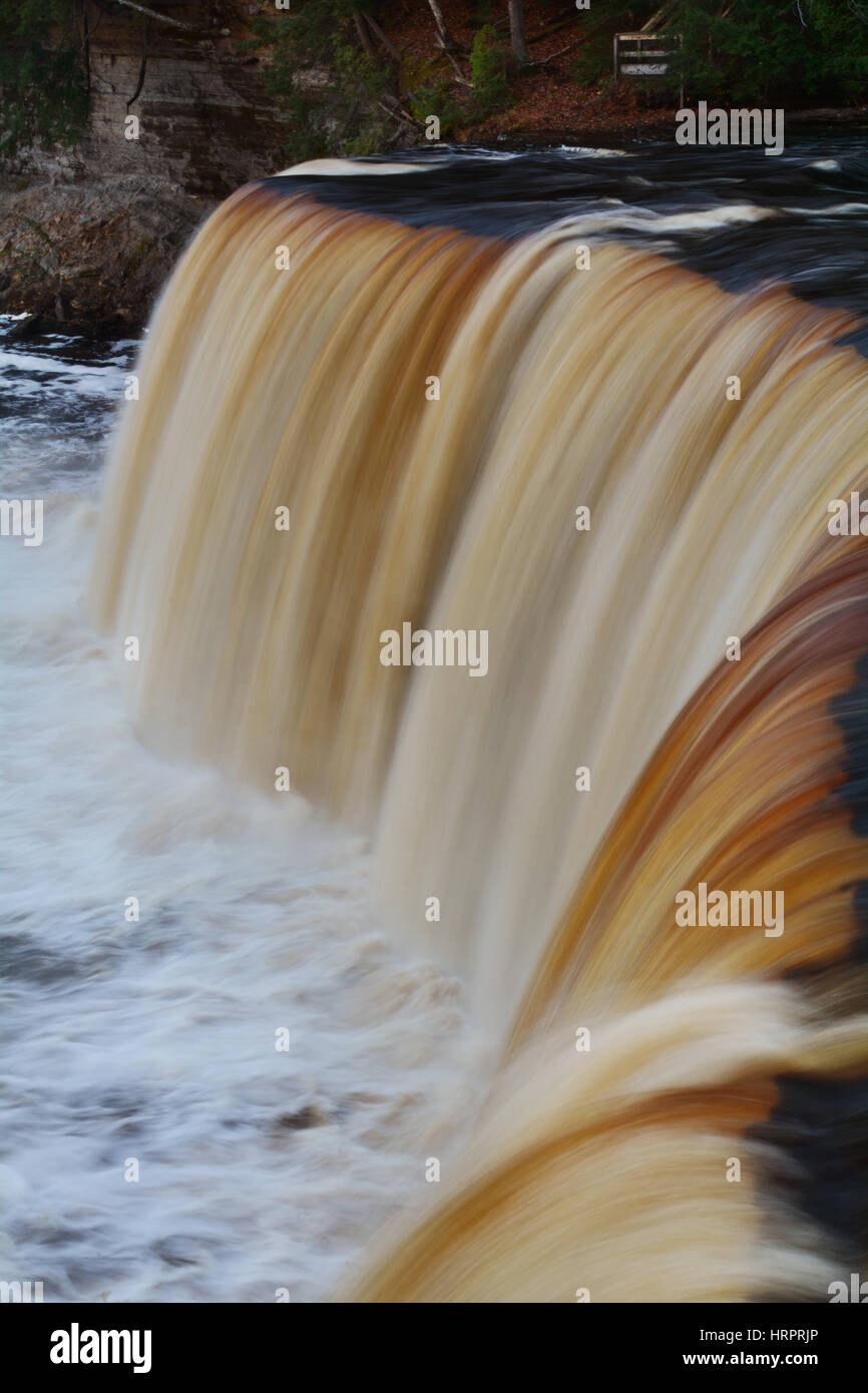 A close-up vertical shot of a waterfall taken with a slow exposure so ...