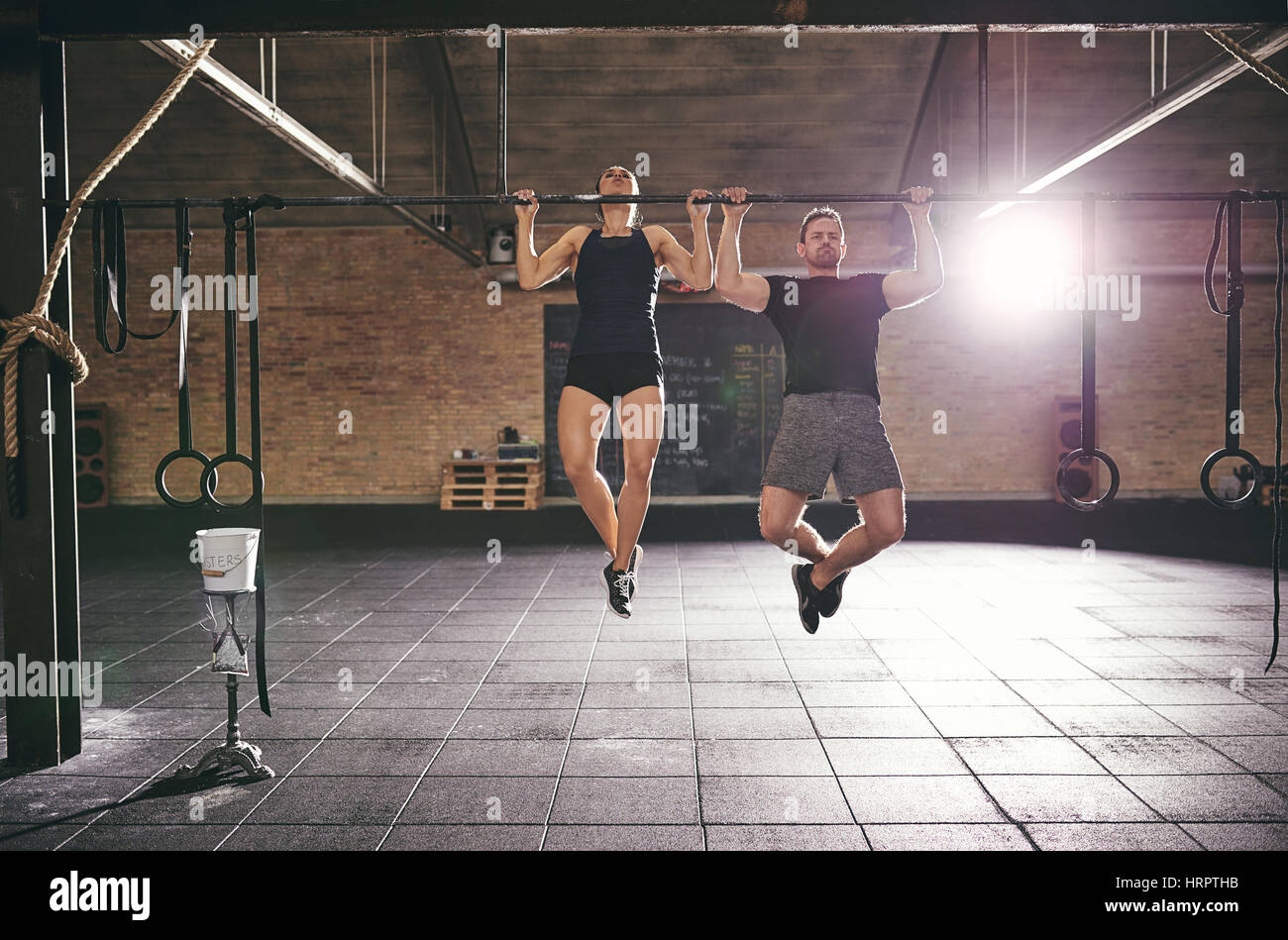 Sporty people doing chin-ups. Horizontal indoors shot Stock Photo - Alamy