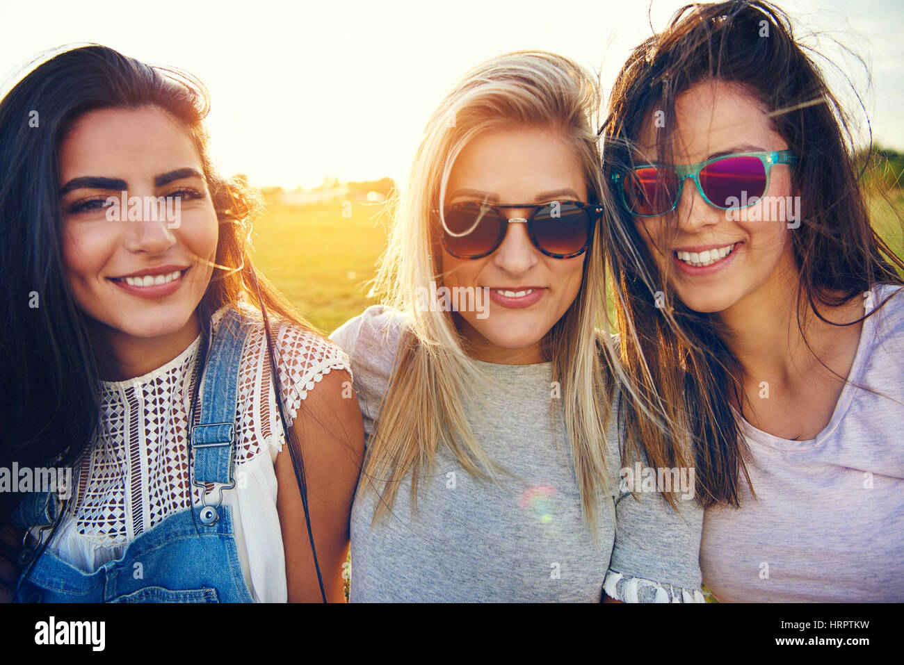 Three young beautiful girls spending time on summer vacation together ...