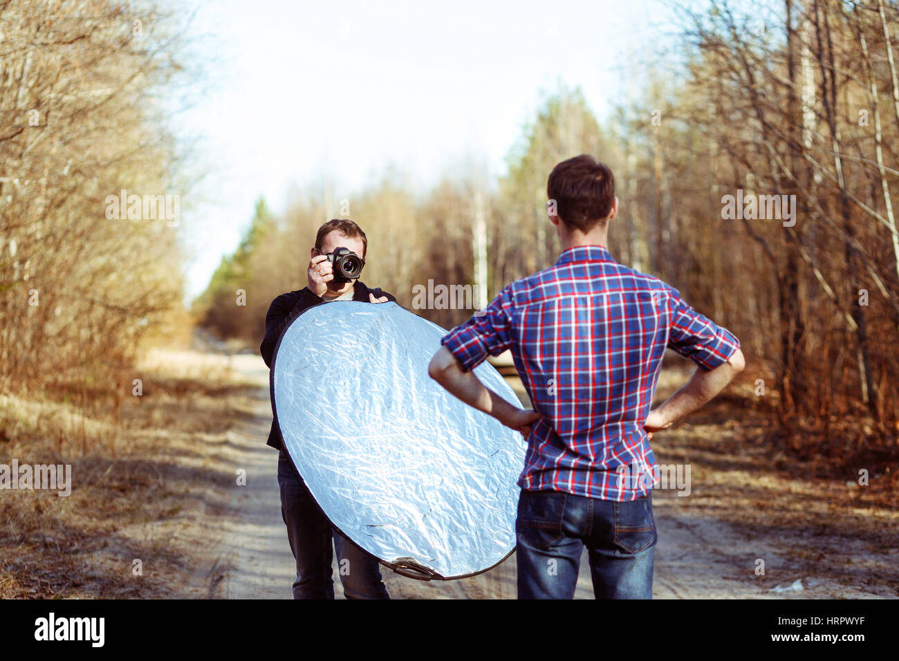Photographer Photographing Male Model in Forest. Backstage of Fashion ...