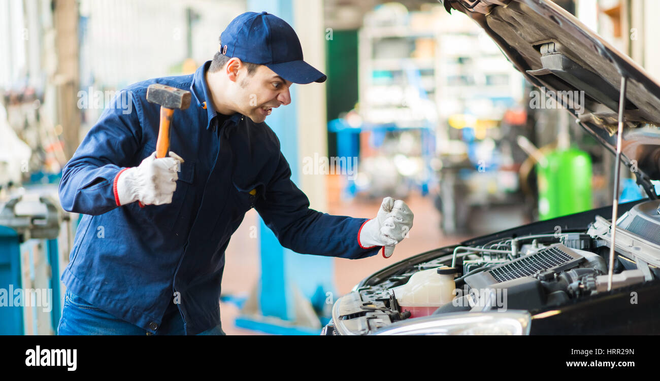Angry mechanic smashing a car engine Stock Photo - Alamy
