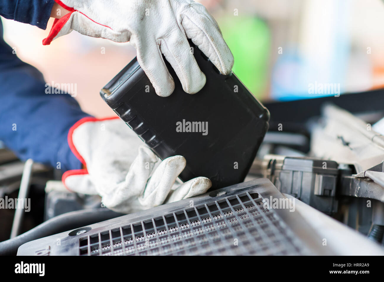 Auto mechanic putting oil in a car engine Stock Photo - Alamy