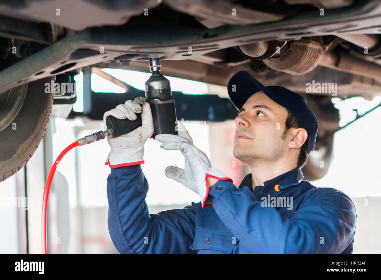 Portrait of a mechanic replacing a wheel Stock Photo - Alamy