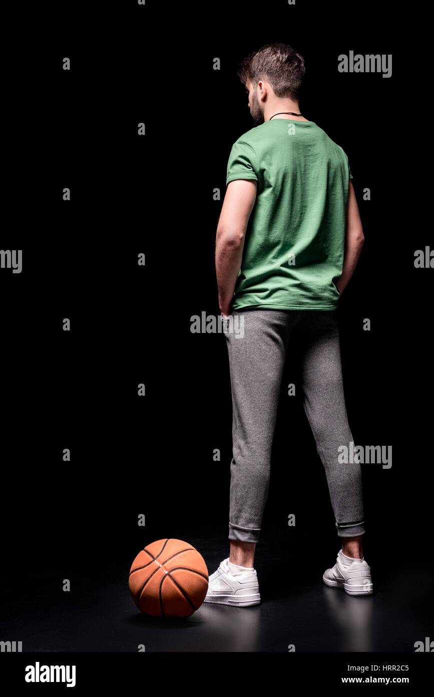 back view of man standing near basketball ball on black Stock Photo - Alamy