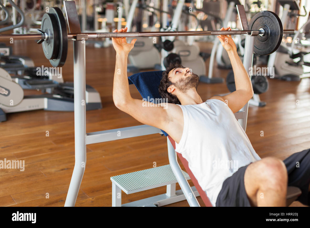 Man lifting a weight in a fitness club Stock Photo - Alamy