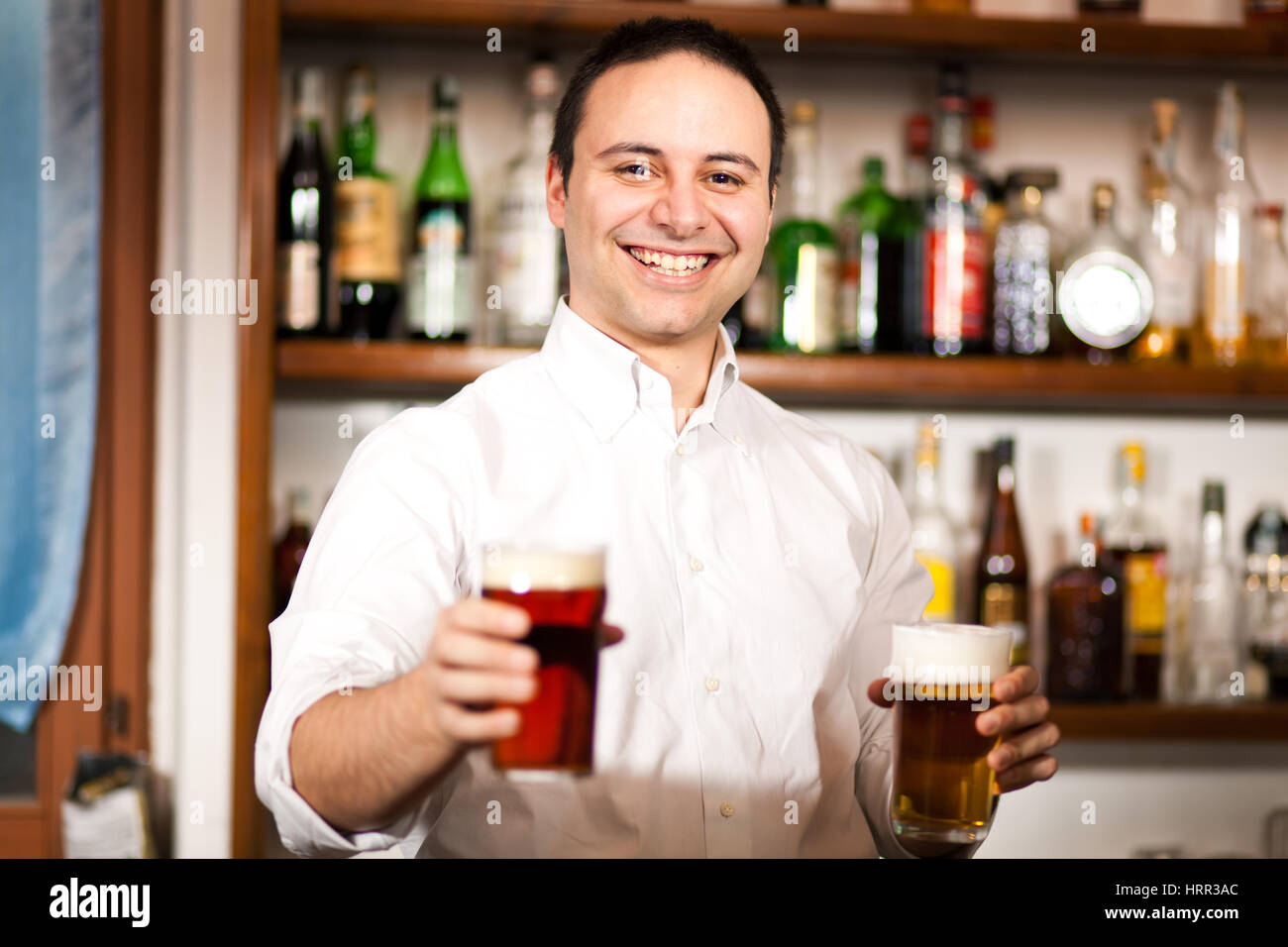 Bartender serving beers Stock Photo - Alamy