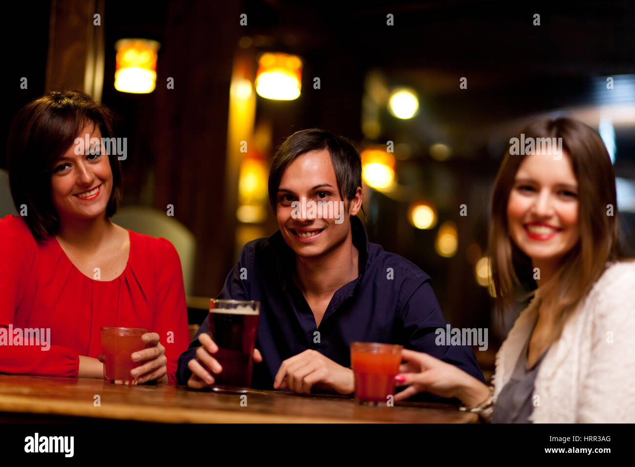 Friends having a round of drinks in a pub Stock Photo - Alamy