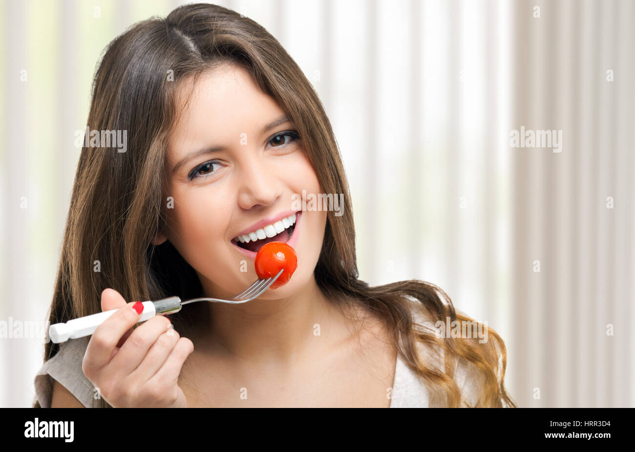 Young woman eating a tomato Stock Photo - Alamy