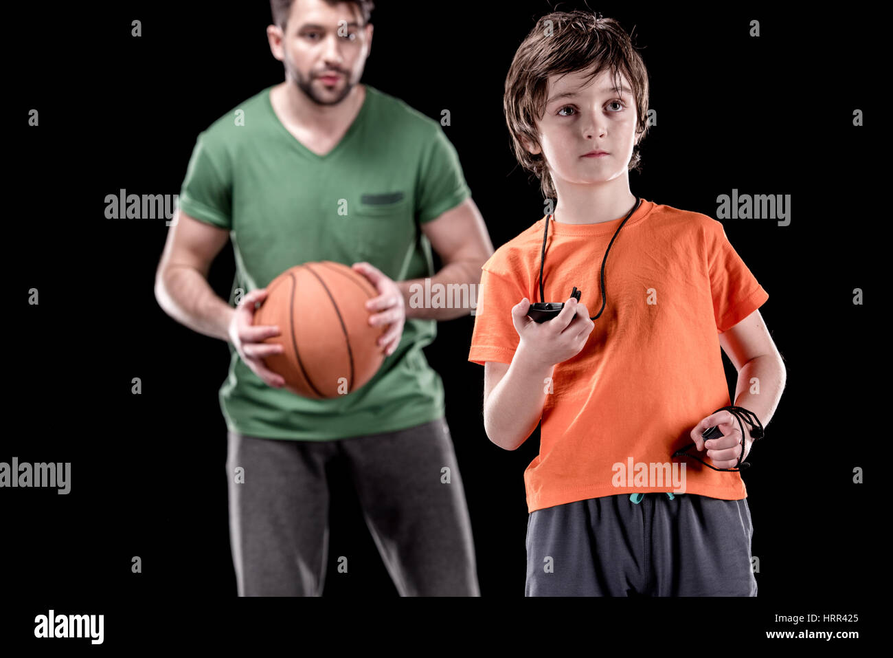 boy with stopwatch controlling time with man holding basketball ball on ...