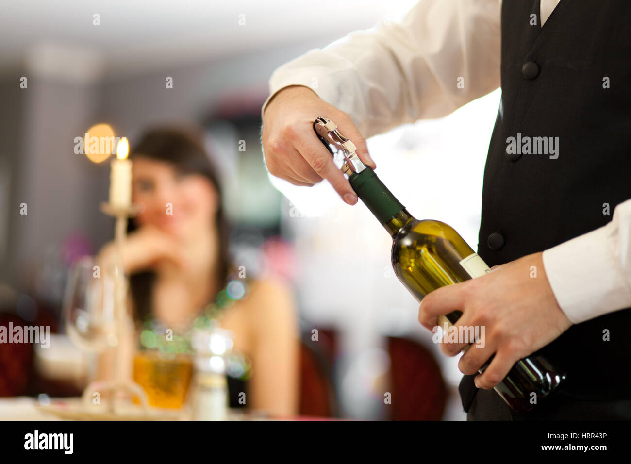 Waiter uncorking a wine bottle in a restaurant Stock Photo - Alamy