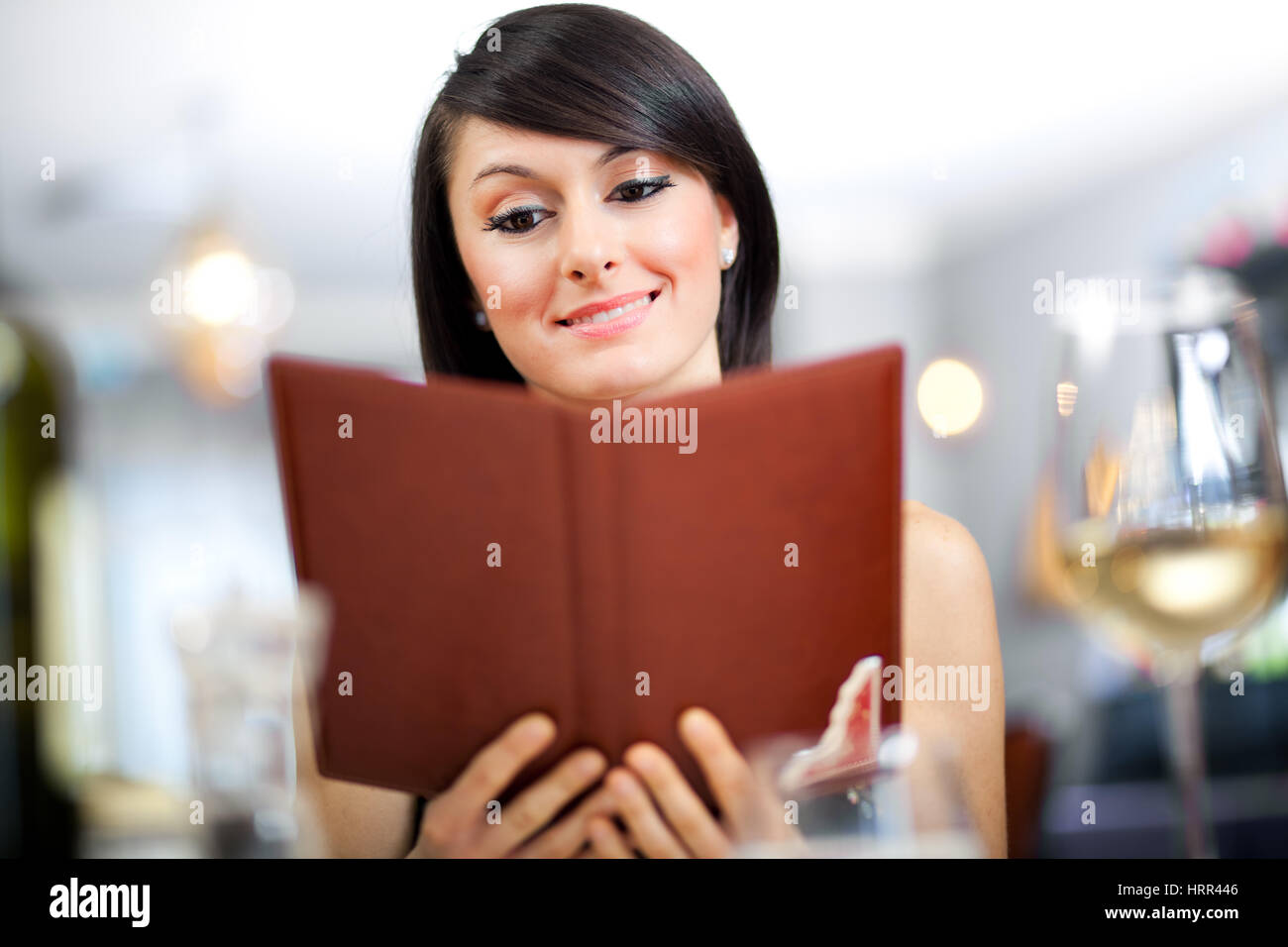 Young woman looking at a menu in the restaurant Stock Photo - Alamy