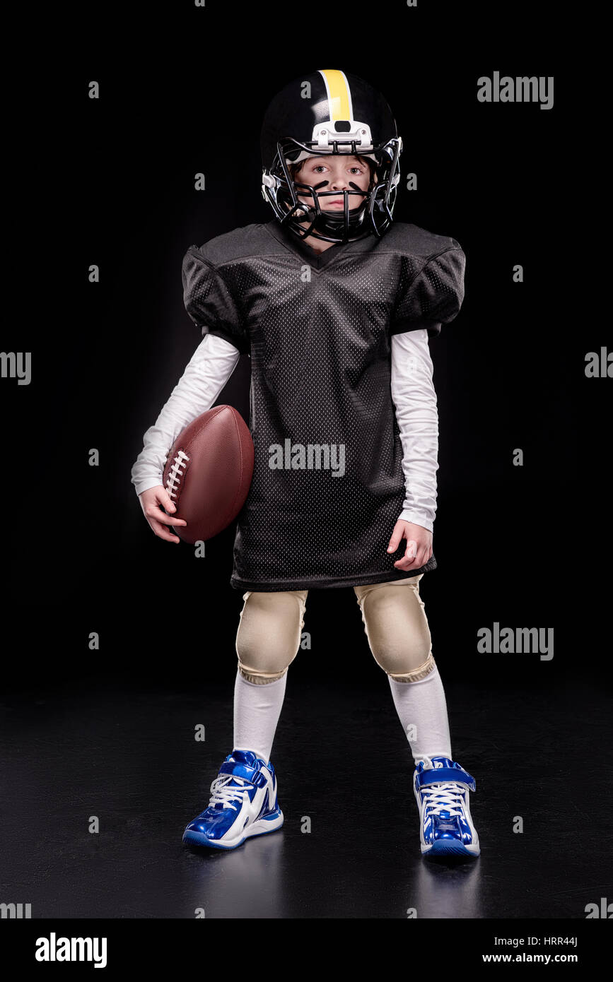 Full length view of little boy american football player in uniform ...