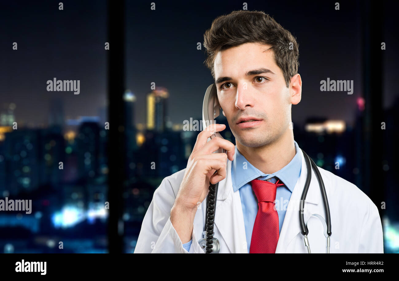 Young doctor on the phone at late night in his studio Stock Photo - Alamy