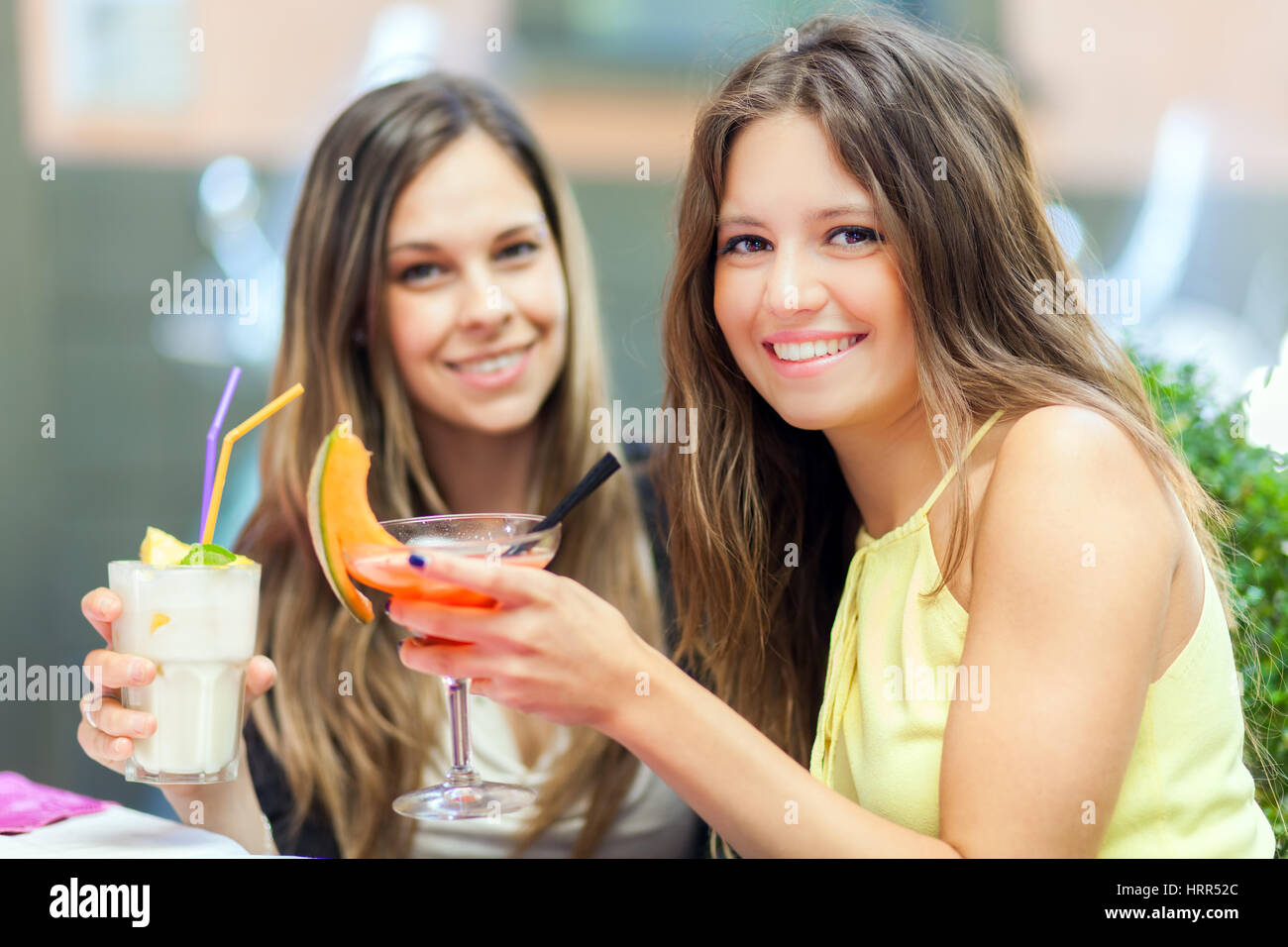 Portrait of two friends drinking a cocktail Stock Photo - Alamy