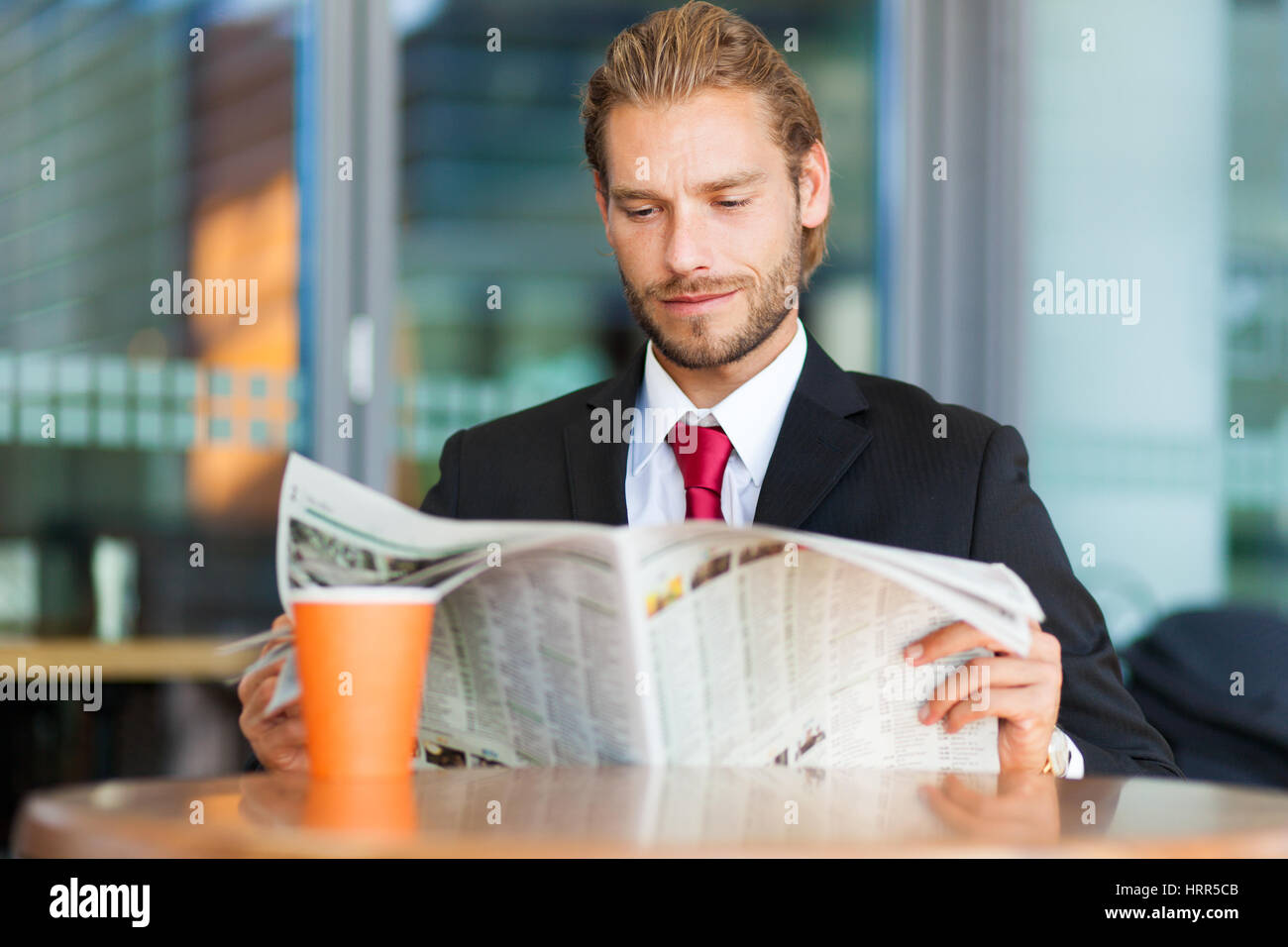 Handsome man with newspaper and coffee Stock Photo - Alamy