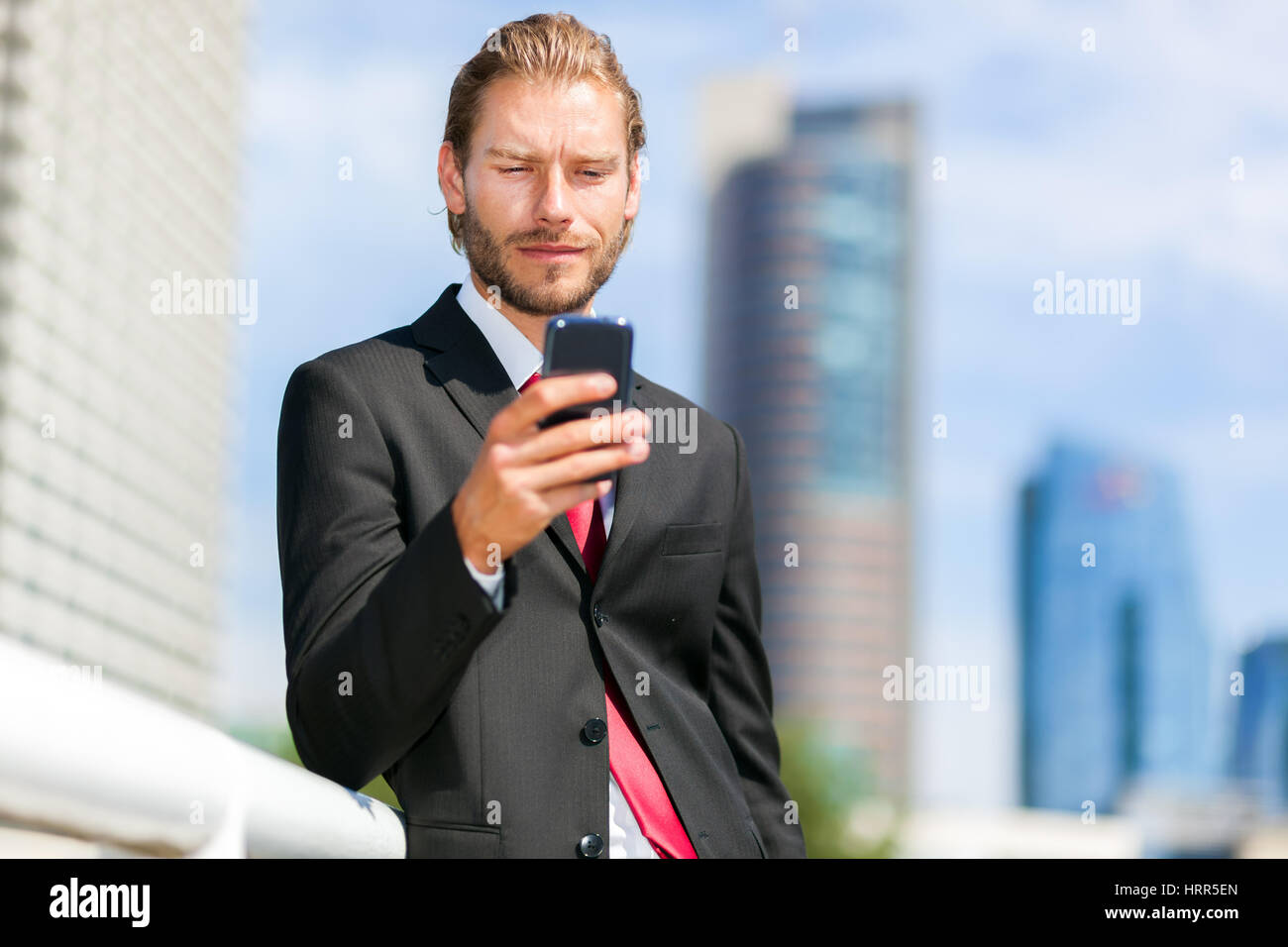 Young businessman using his phone Stock Photo - Alamy
