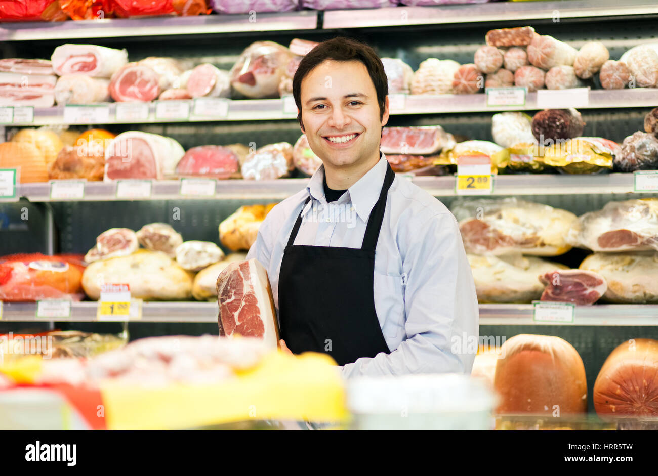 Smiling butcher in his grocery store Stock Photo - Alamy