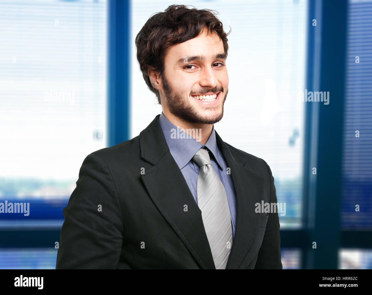 Smiling businessman in his office Stock Photo - Alamy
