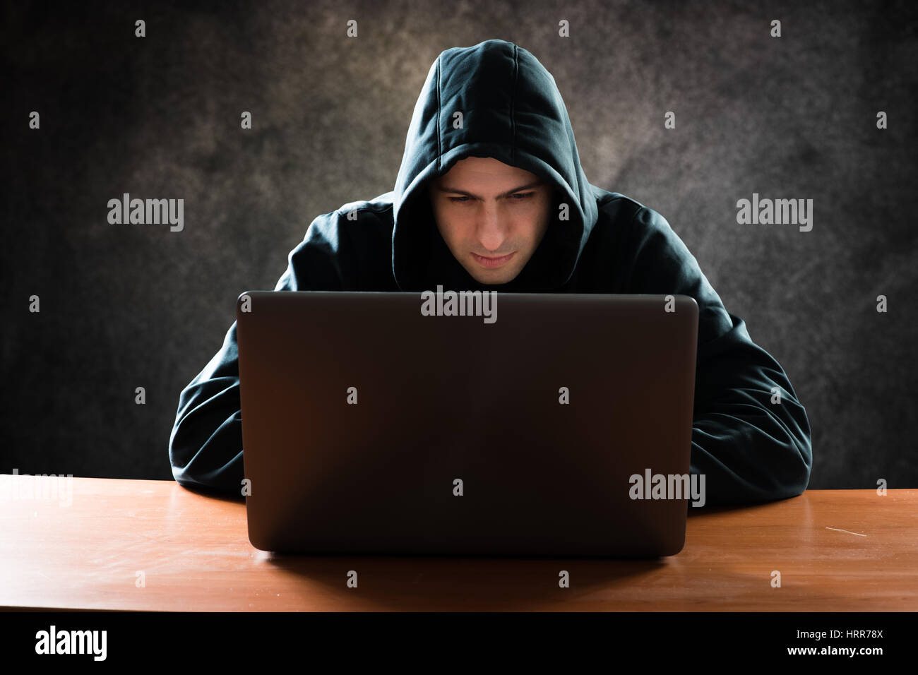 Hooded computer hacker stealing information with laptop Stock Photo - Alamy