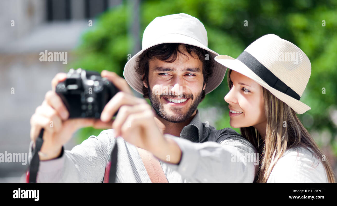 Smiling tourist showing photos to his girlfriend Stock Photo - Alamy