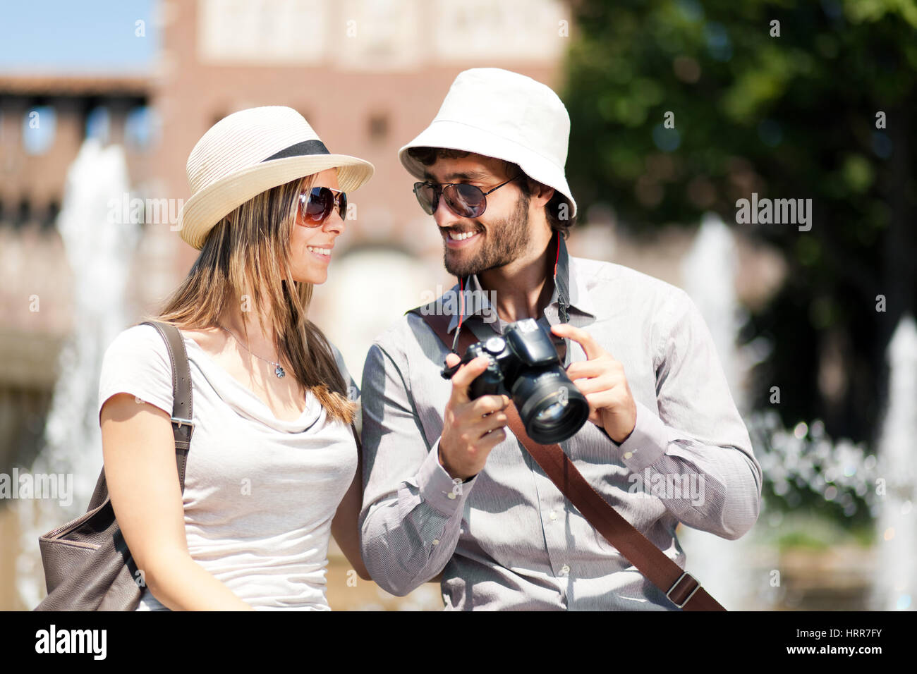 Smiling tourist showing photos to his girlfriend Stock Photo - Alamy