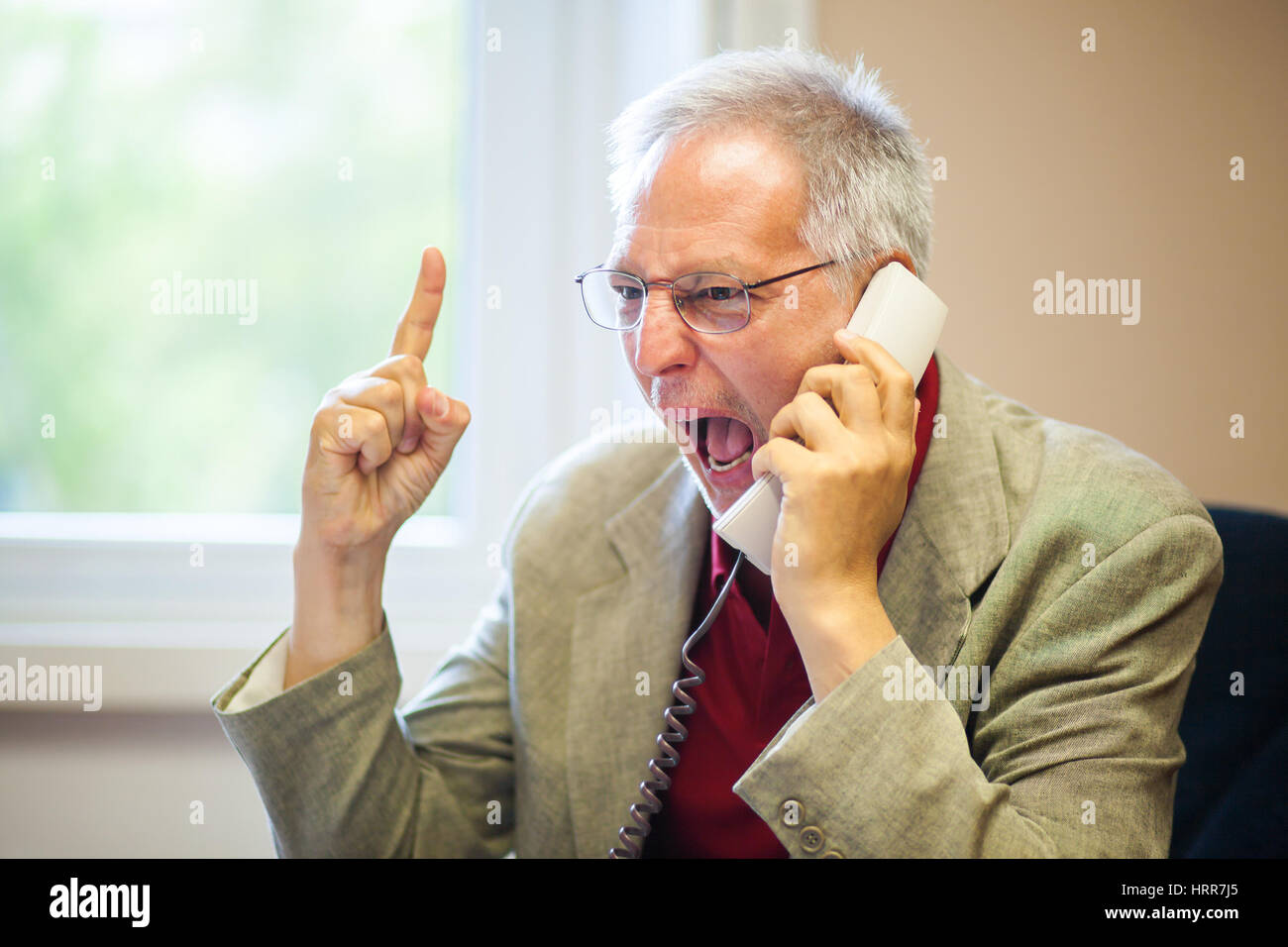 Angry senior businessman yelling at the phone Stock Photo - Alamy