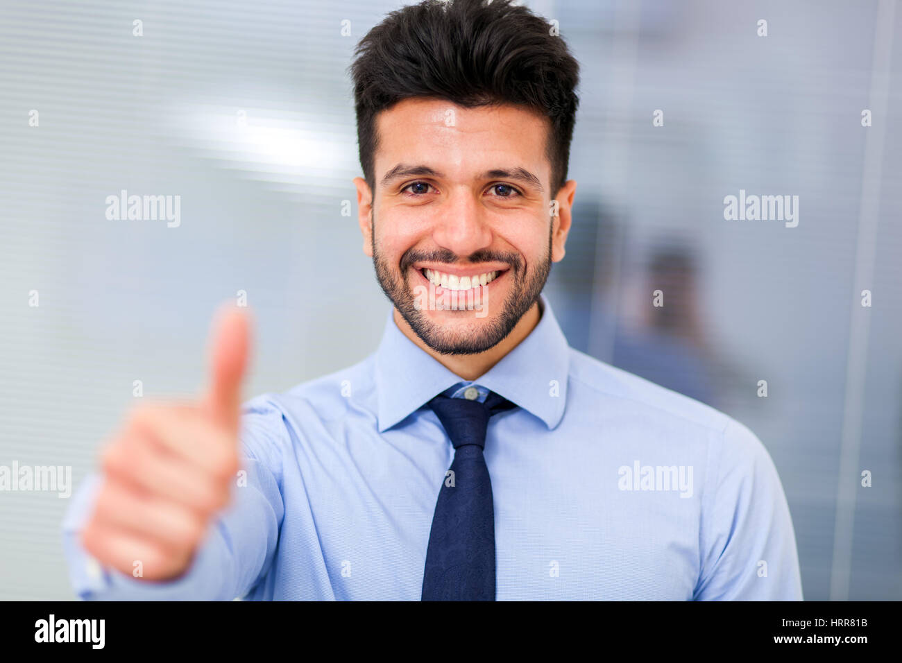 Portrait of a smiling business man giving thumbs up Stock Photo - Alamy