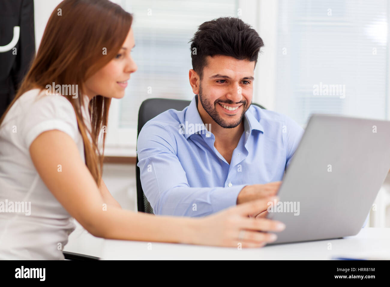 Business people using a laptop computer in their office Stock Photo - Alamy