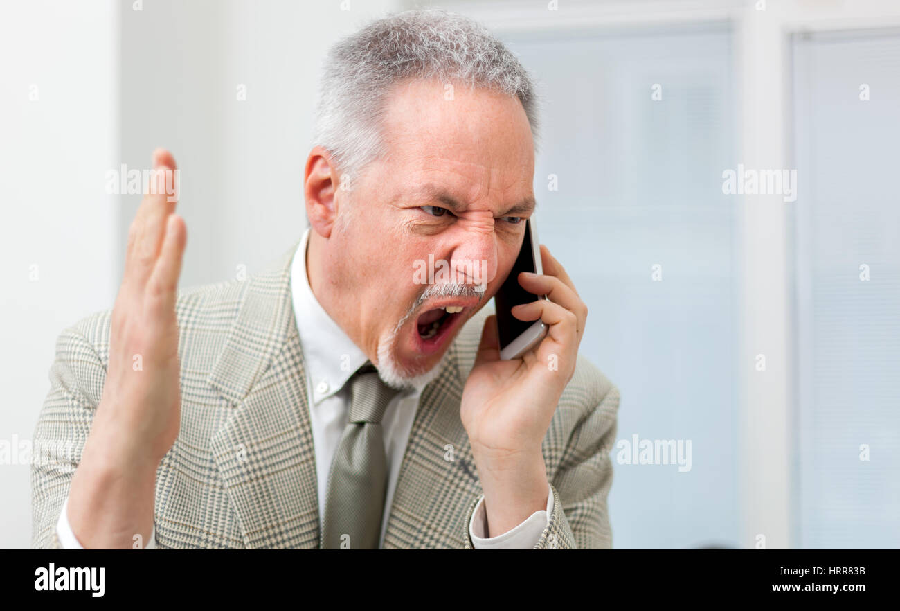 Angry businessman shouting on the phone Stock Photo - Alamy