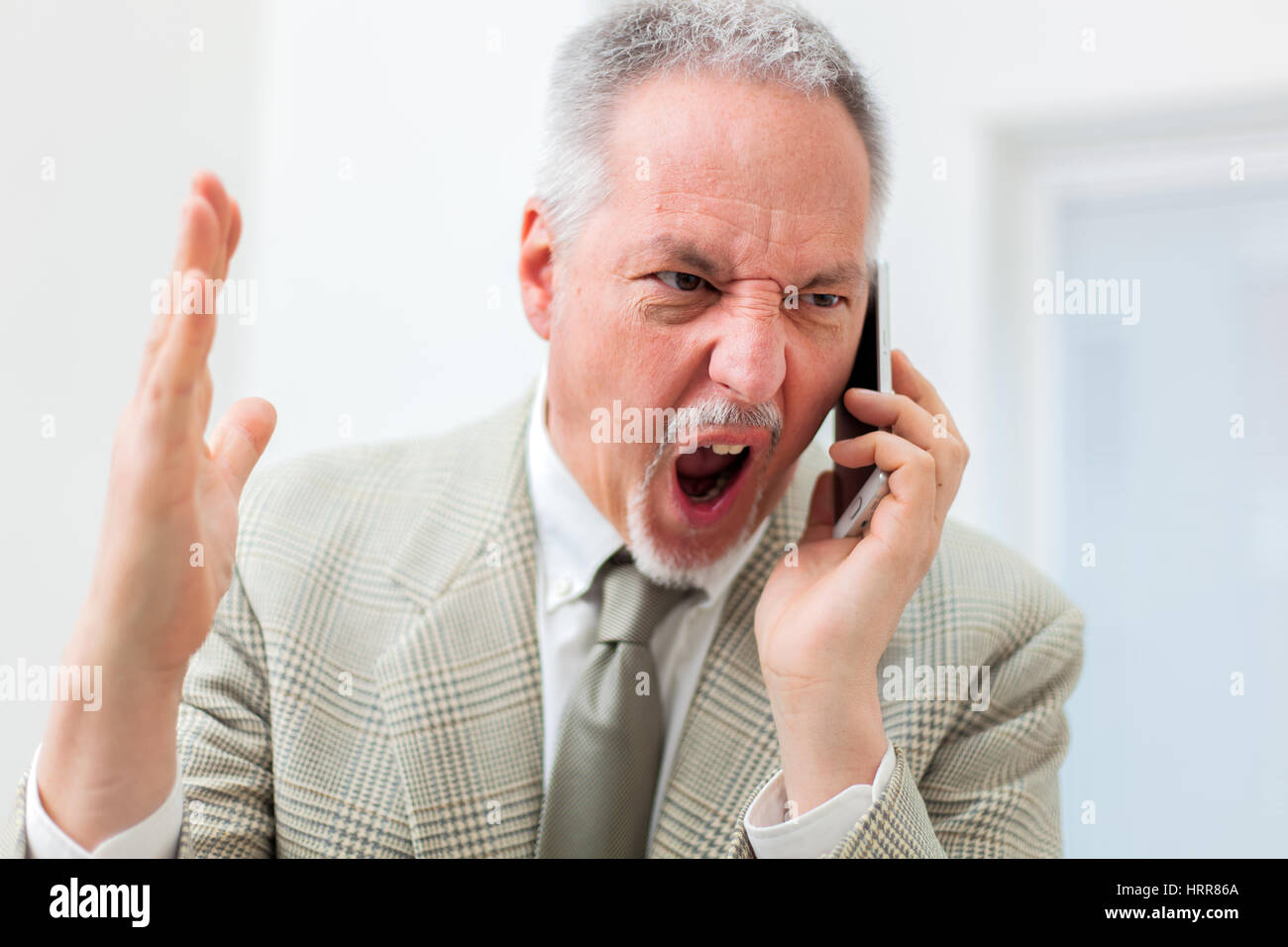 Angry businessman shouting on the phone Stock Photo - Alamy